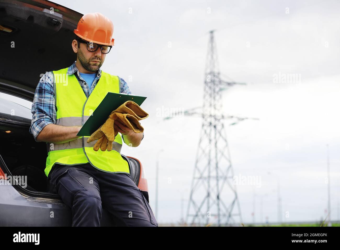 A man in a helmet and uniform, an electrician in the field ...