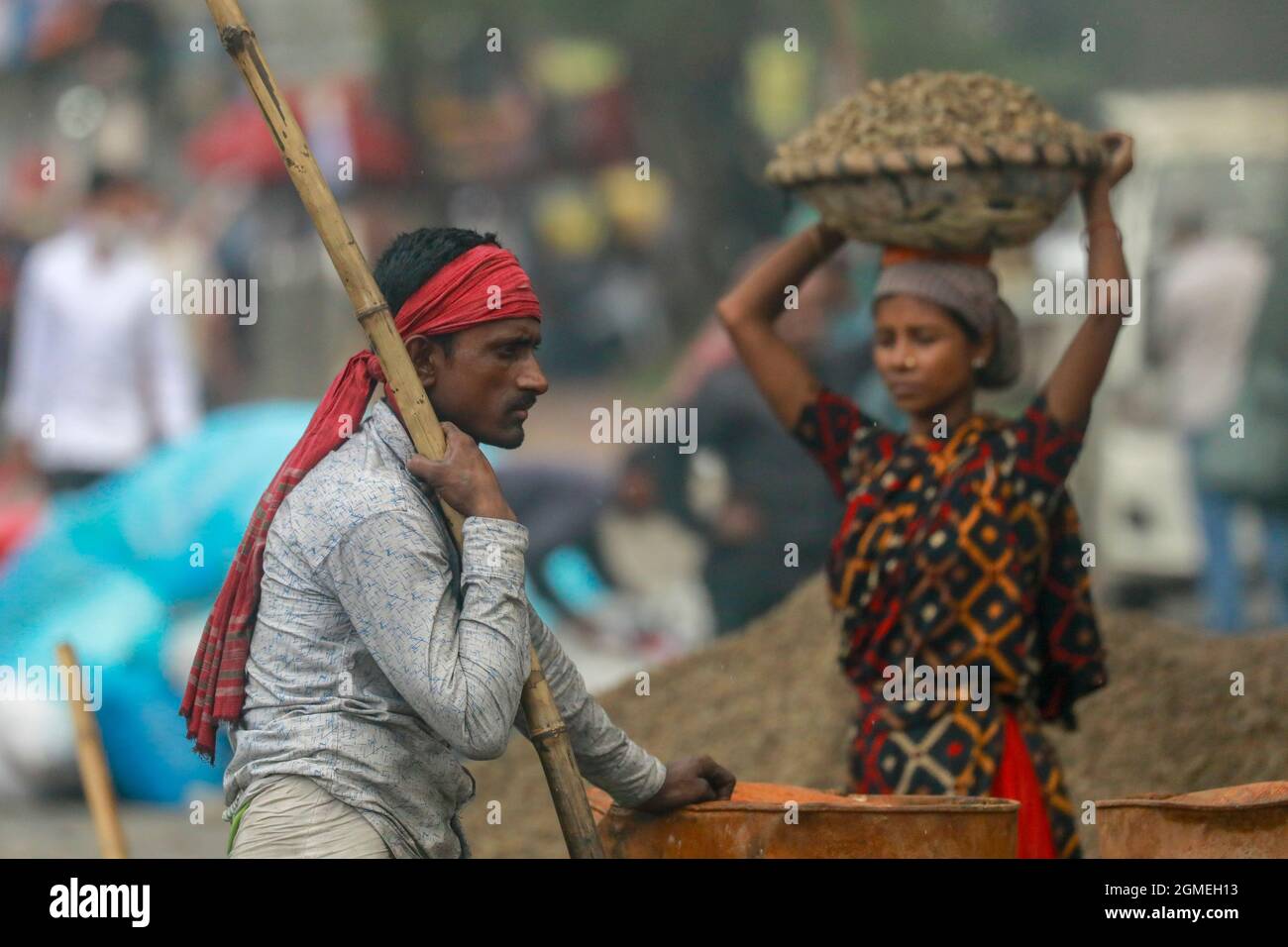 DHAKA, BANGLADESH - SEPTEMBER 17, 2021: A migrant road labor lifts ...