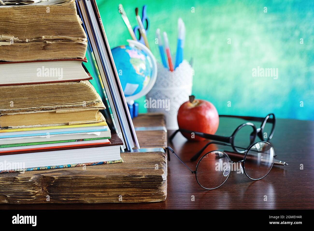 Education concept. A stack of textbooks and a book on the desk with ...