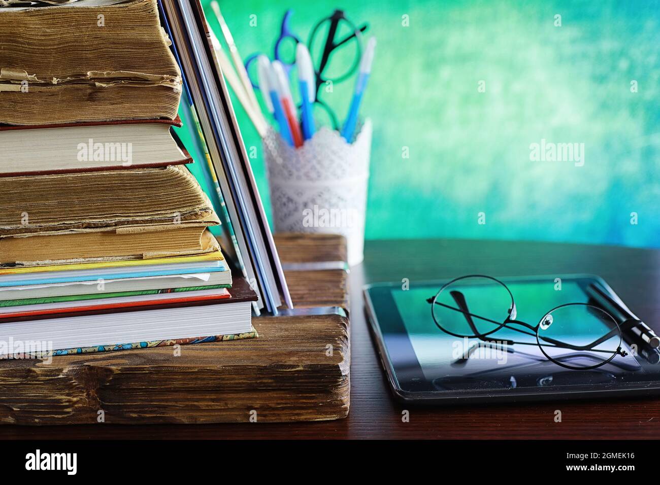 Education concept. A stack of textbooks and a book on the desk with ...
