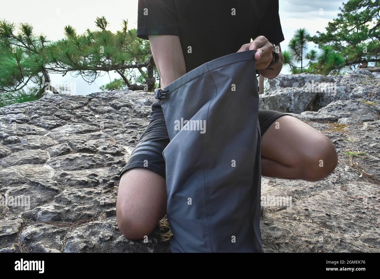 A man seeking something in grey color dry bag and landscape of cliff in ...