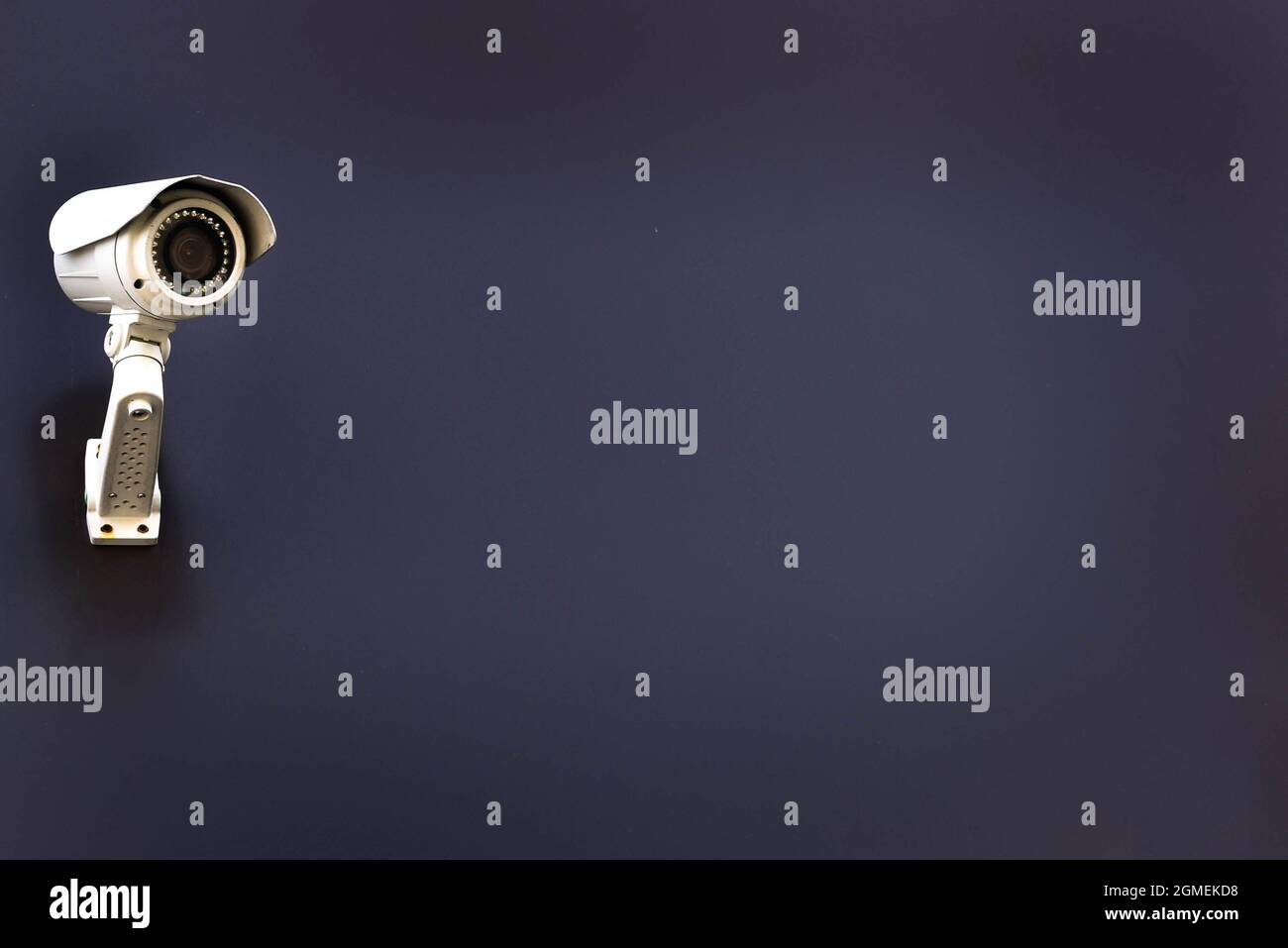 Surveillance Camera on left corner black color wall Stock Photo - Alamy