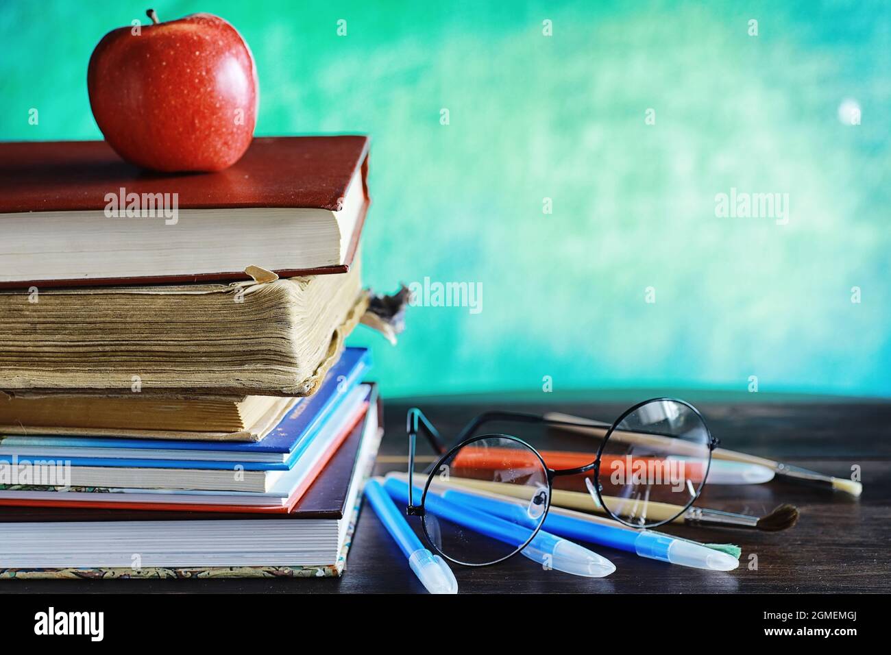 Education concept. A stack of textbooks and a book on the desk with ...