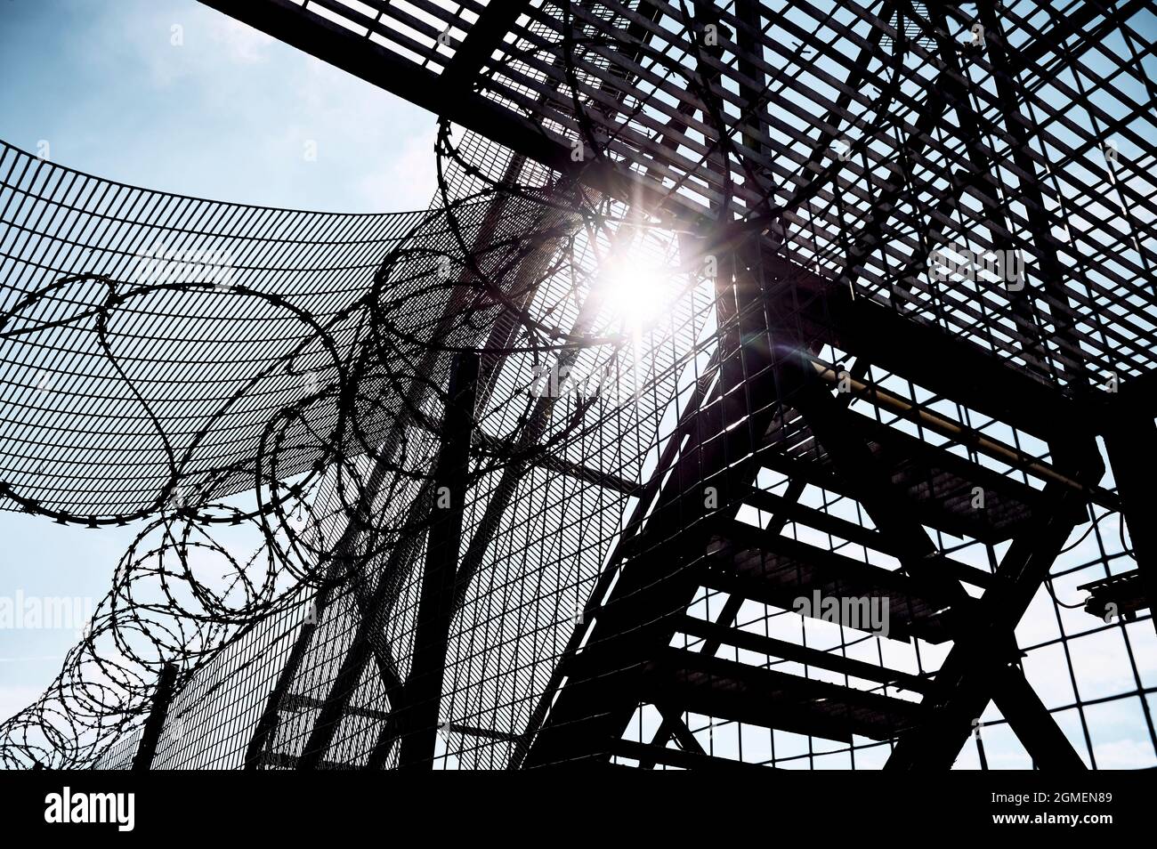 Sunlight shining through high security fence around compound Stock ...
