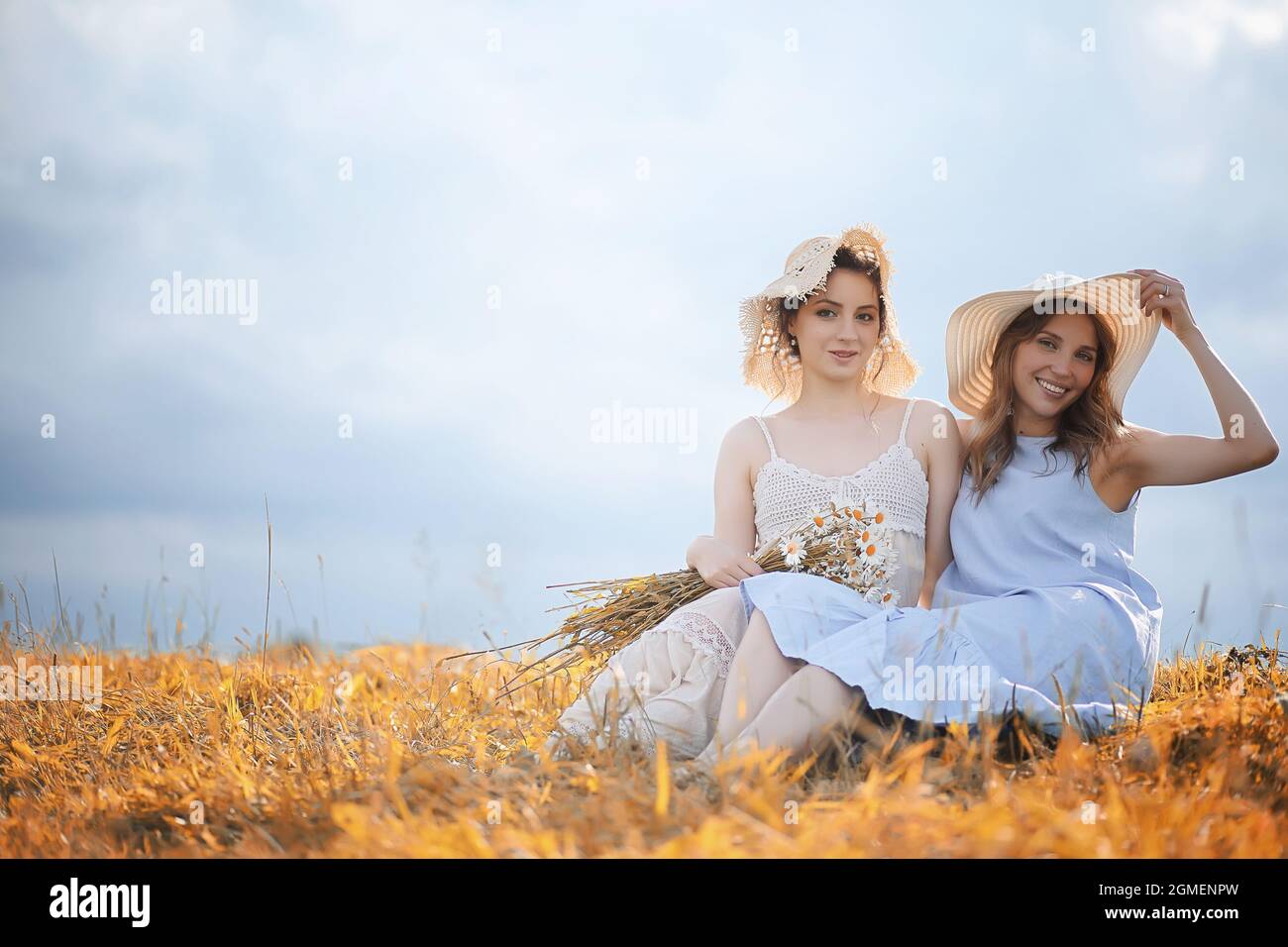 Two beautiful girls in dresses in autumn field have fun Stock Photo - Alamy