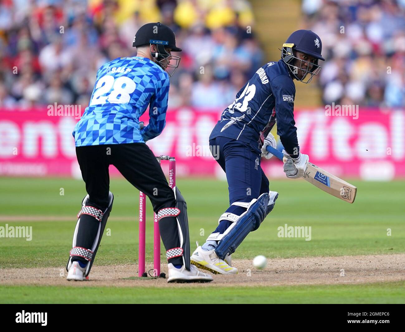 Kent's Daniel Bell-Drummond (right) strikes the ball as it goes past ...