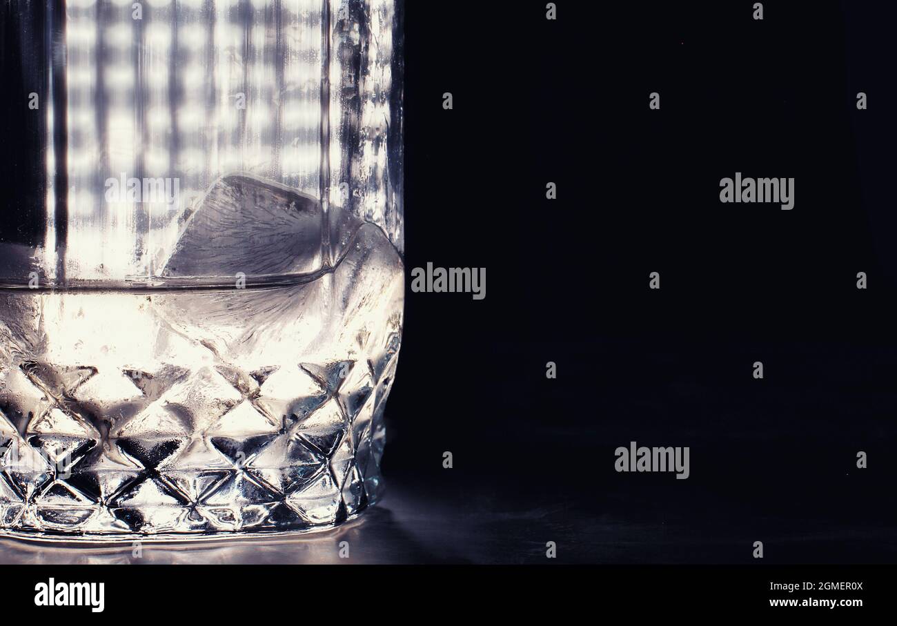A glass of hard alcohol with ice on a bar counter. Whiskey with soda in ...
