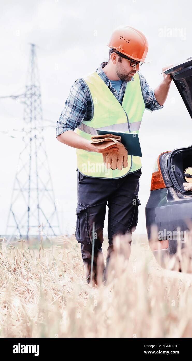 A man in a helmet and uniform, an electrician in the field ...