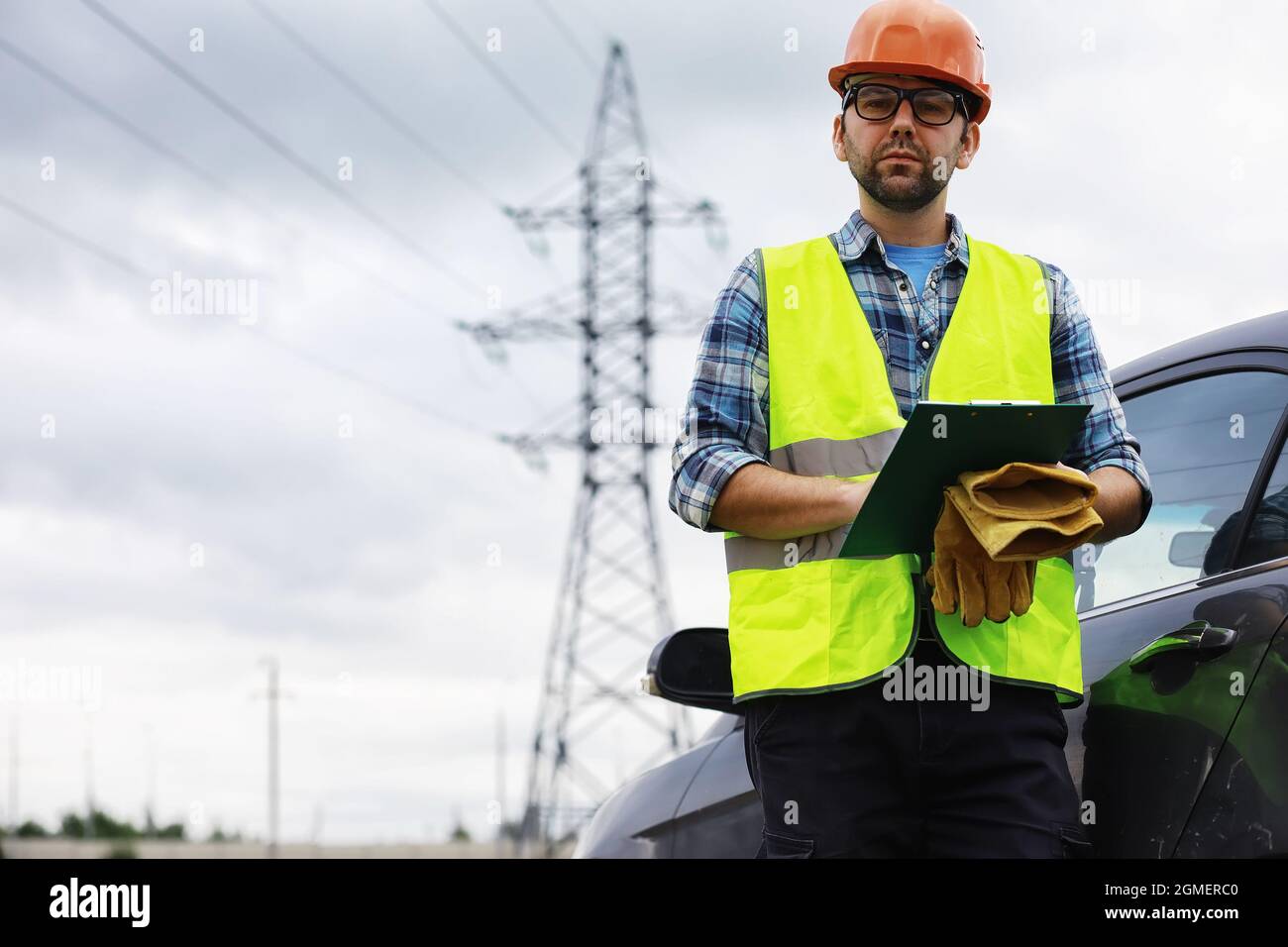A man in a helmet and uniform, an electrician in the field ...