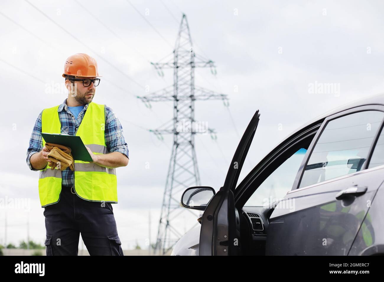 A man in a helmet and uniform, an electrician in the field ...