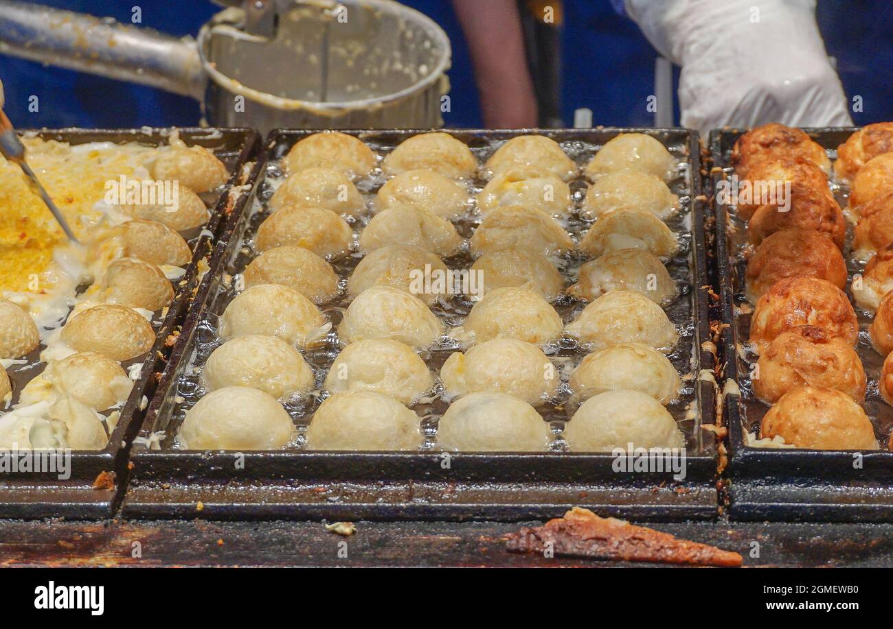 Making takoyaki process, ball shaped Japanese food in hot pan with ...