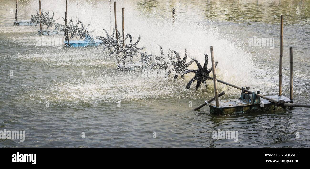 Hydraulic water wheel turbine machine spinning in pond Stock Photo - Alamy