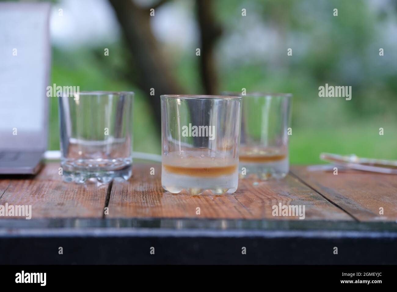 Glasses with whiskey at bottom are on table in bar closeup. Alcohol ...