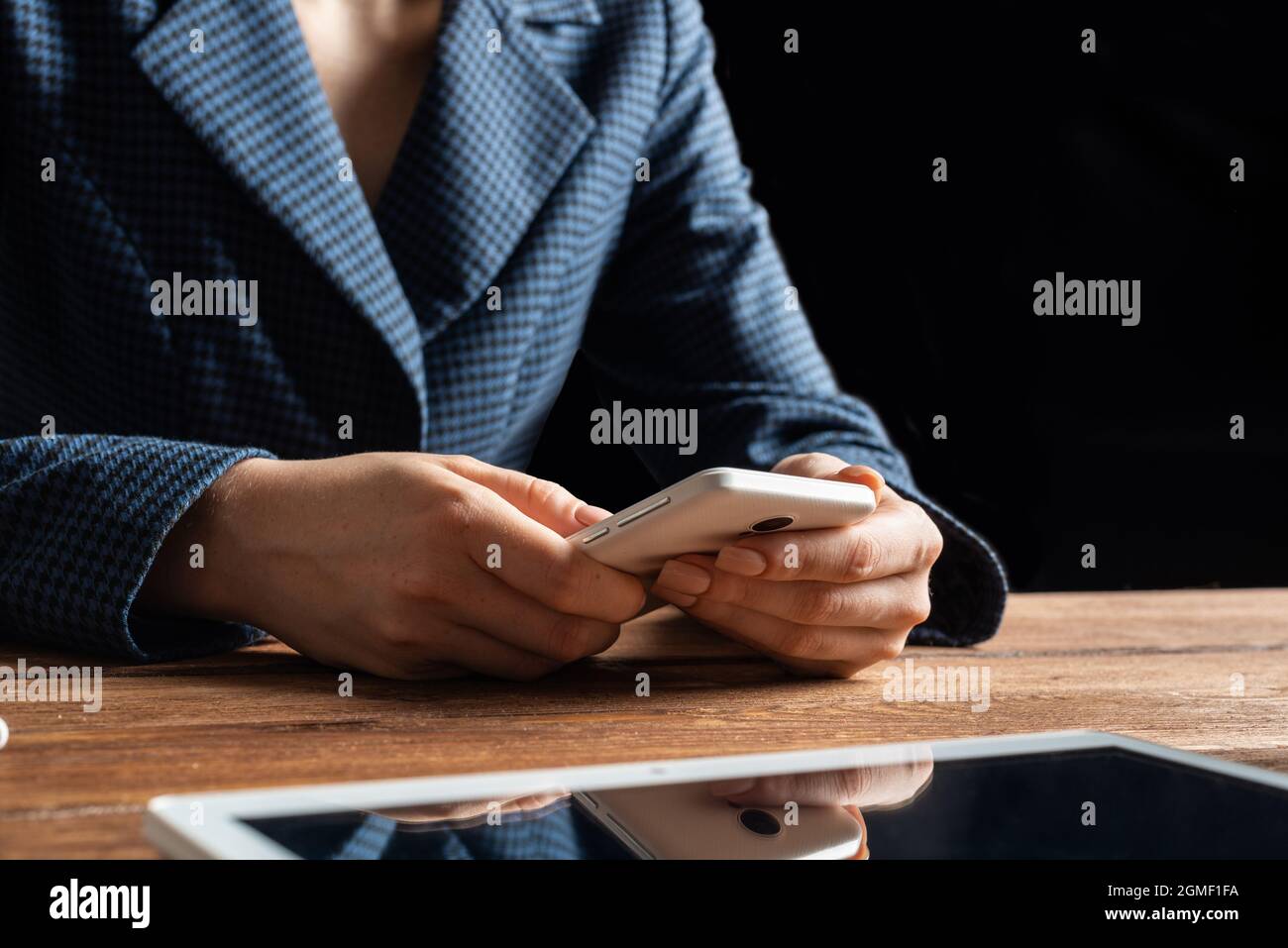 Businesswoman using mobile phone at desk Stock Photo - Alamy