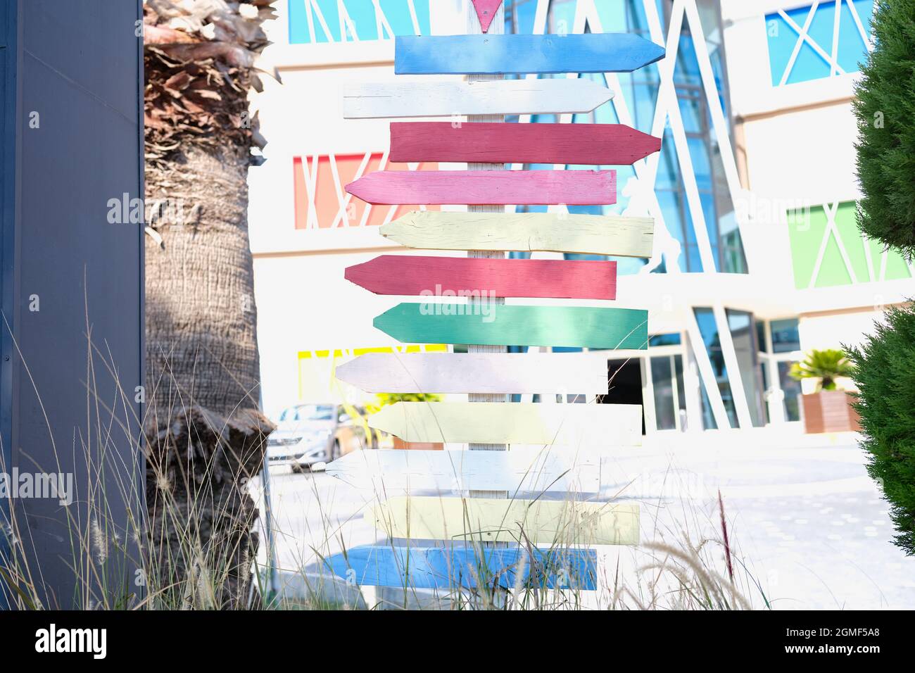 Pillar with many wooden signs in form of arrows with directions ...