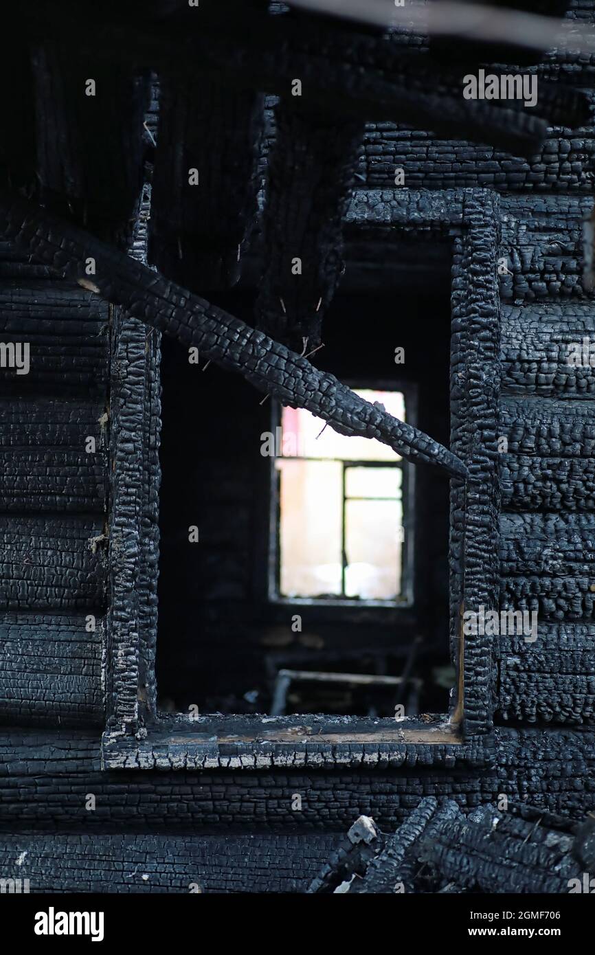 Wooden house after the fire. Coals on the logs. The ashes of the house ...