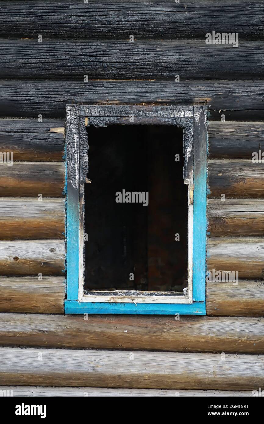 Wooden house after the fire. Coals on the logs. The ashes of the house ...