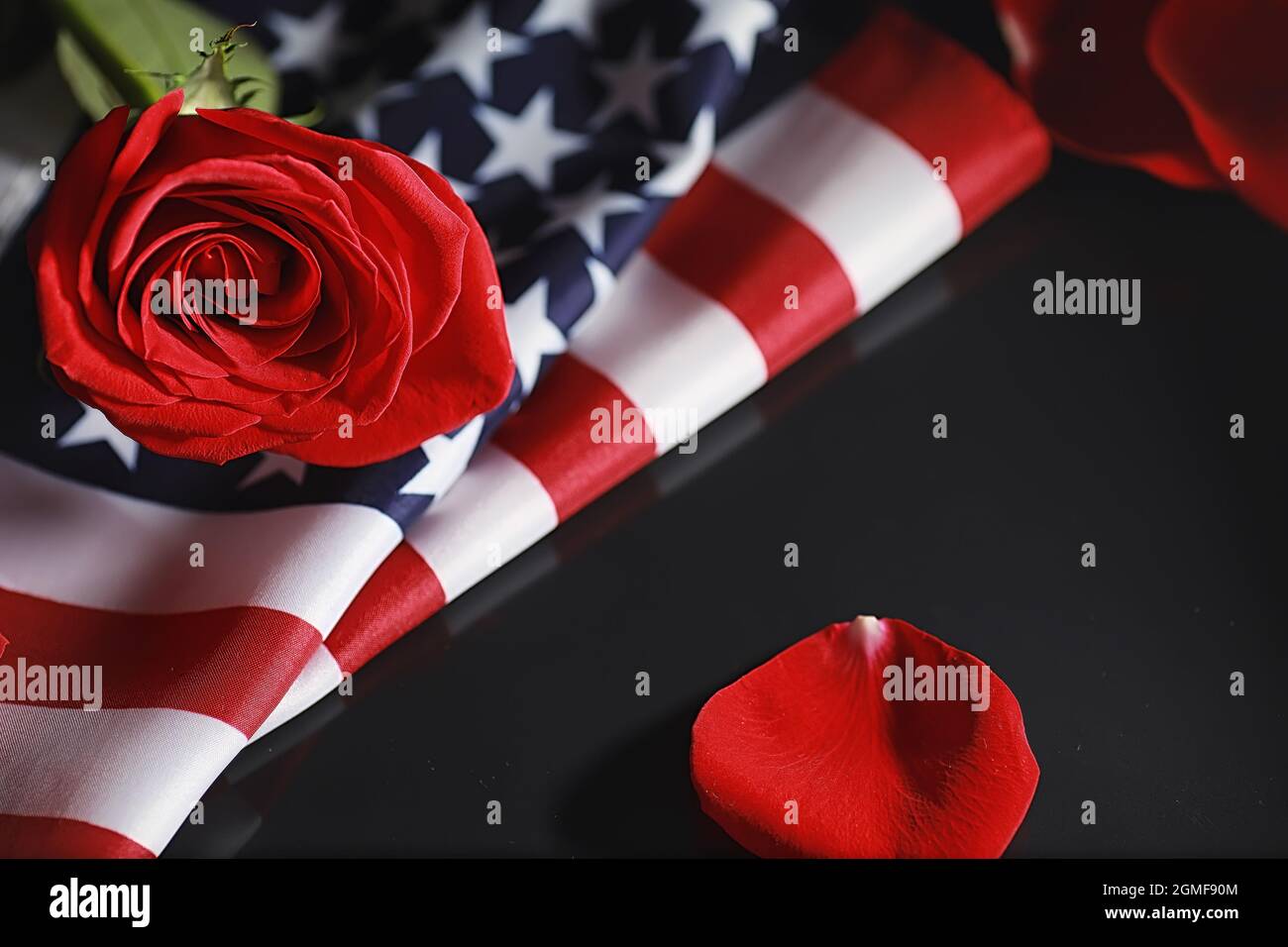 American flag and rose flower on table. Symbol of the United States of ...