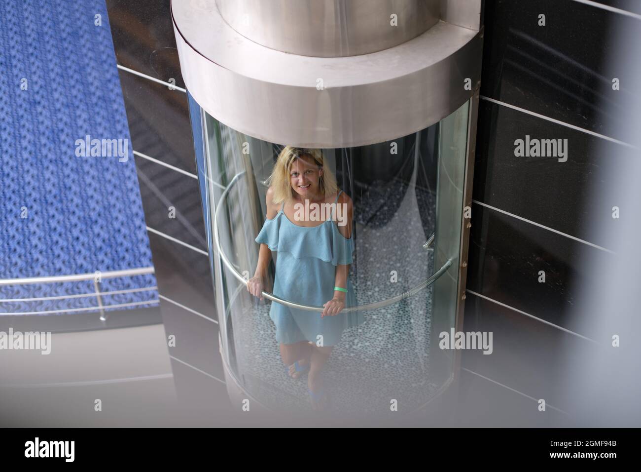 Young woman riding in glass transparent elevator in hotel Stock Photo ...