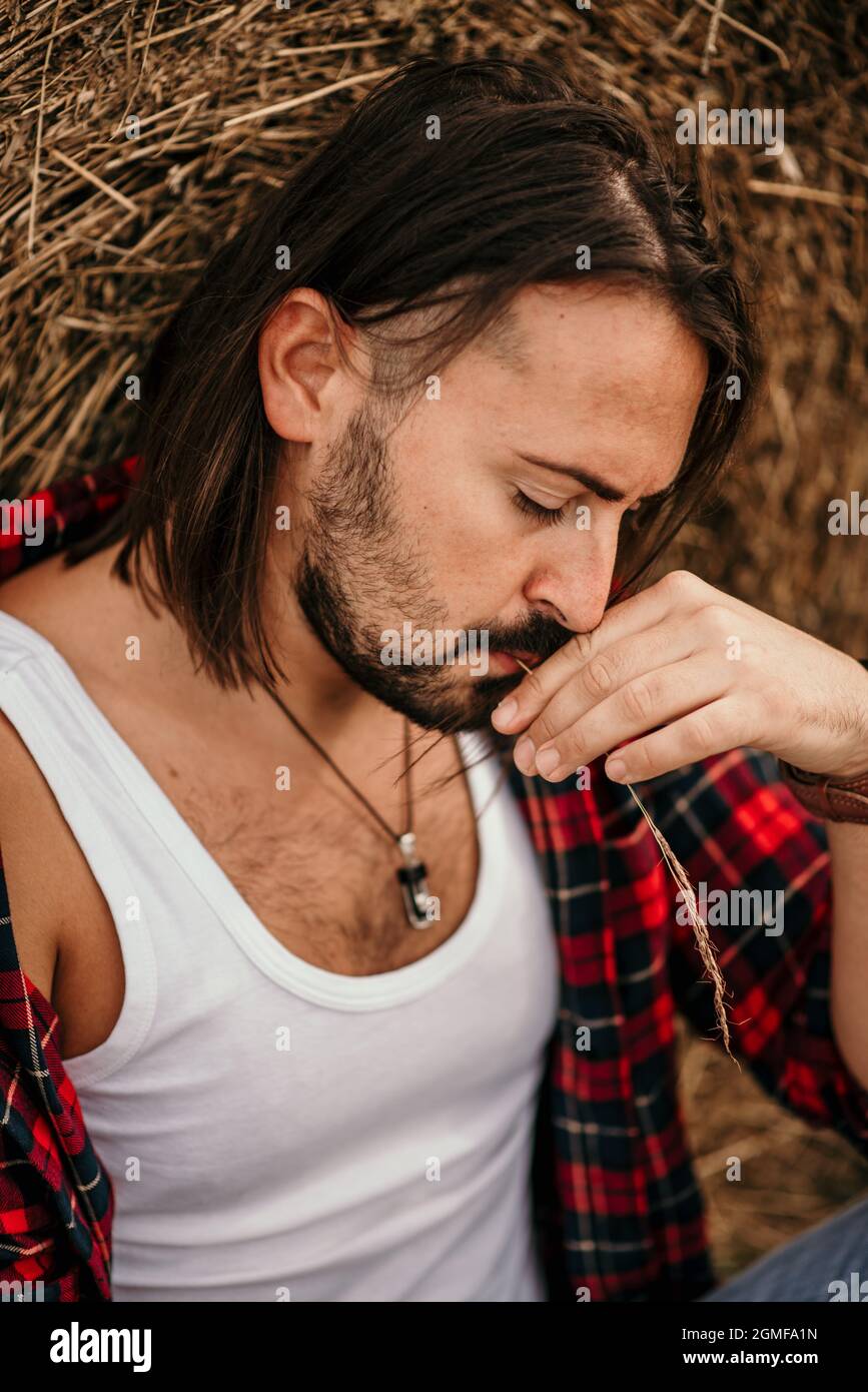 Young handsome Serbian male in a flannel shirt and ripped jeans sitting ...