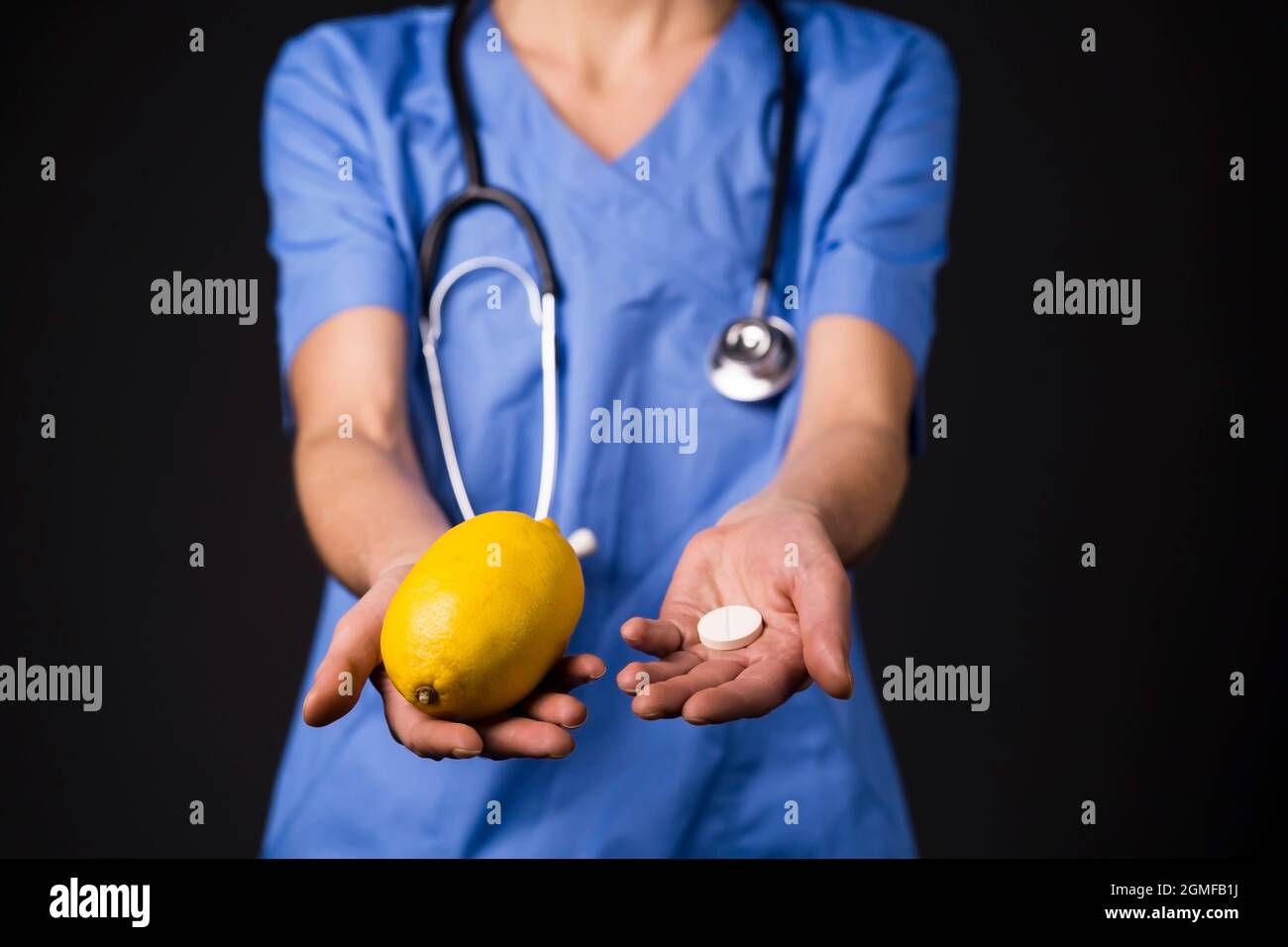 A girl cheerful doctor in a medical suit and with a stethoscope holds a ...