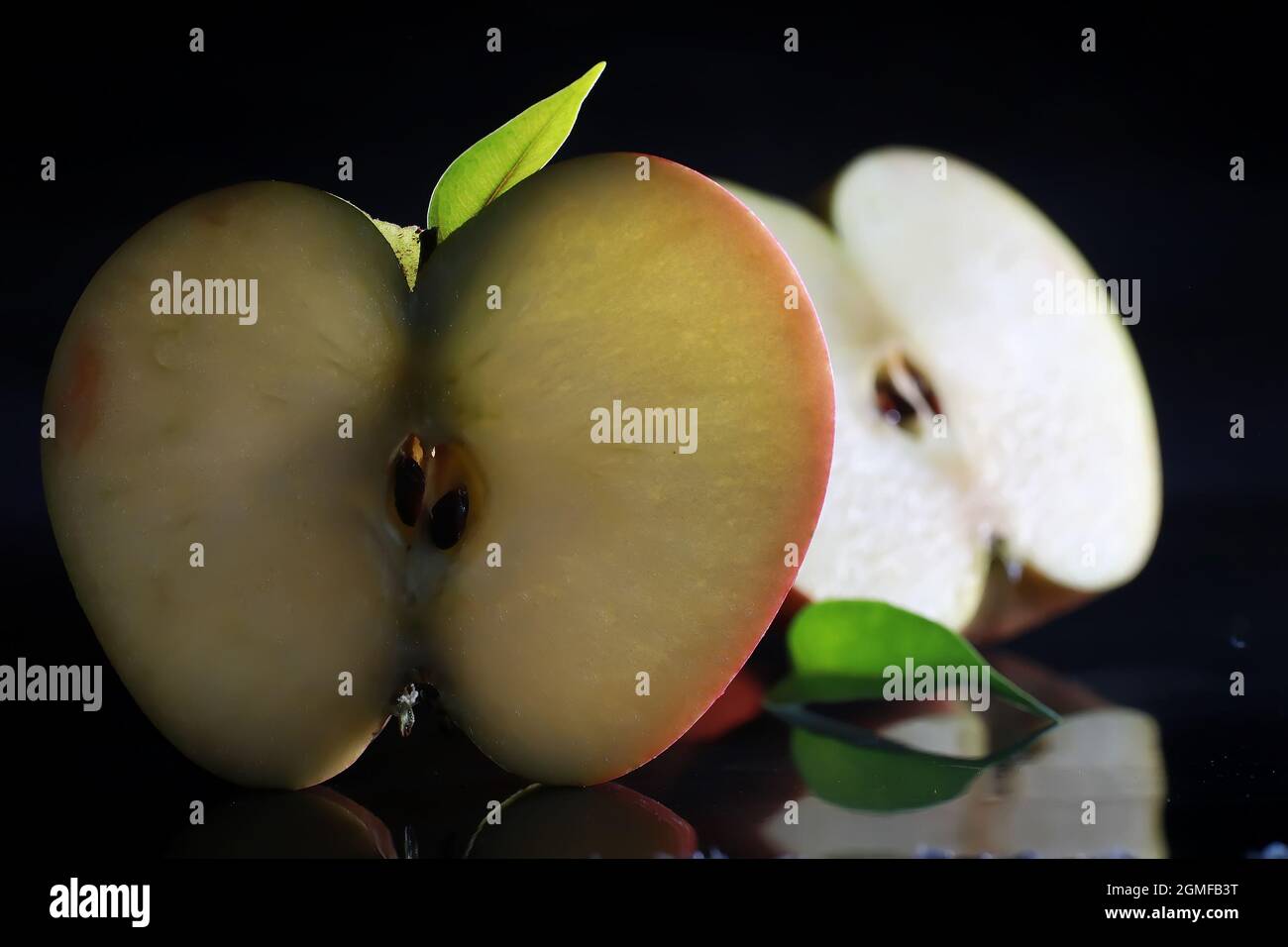Composition with apple slices on a black background. A slice of apple ...