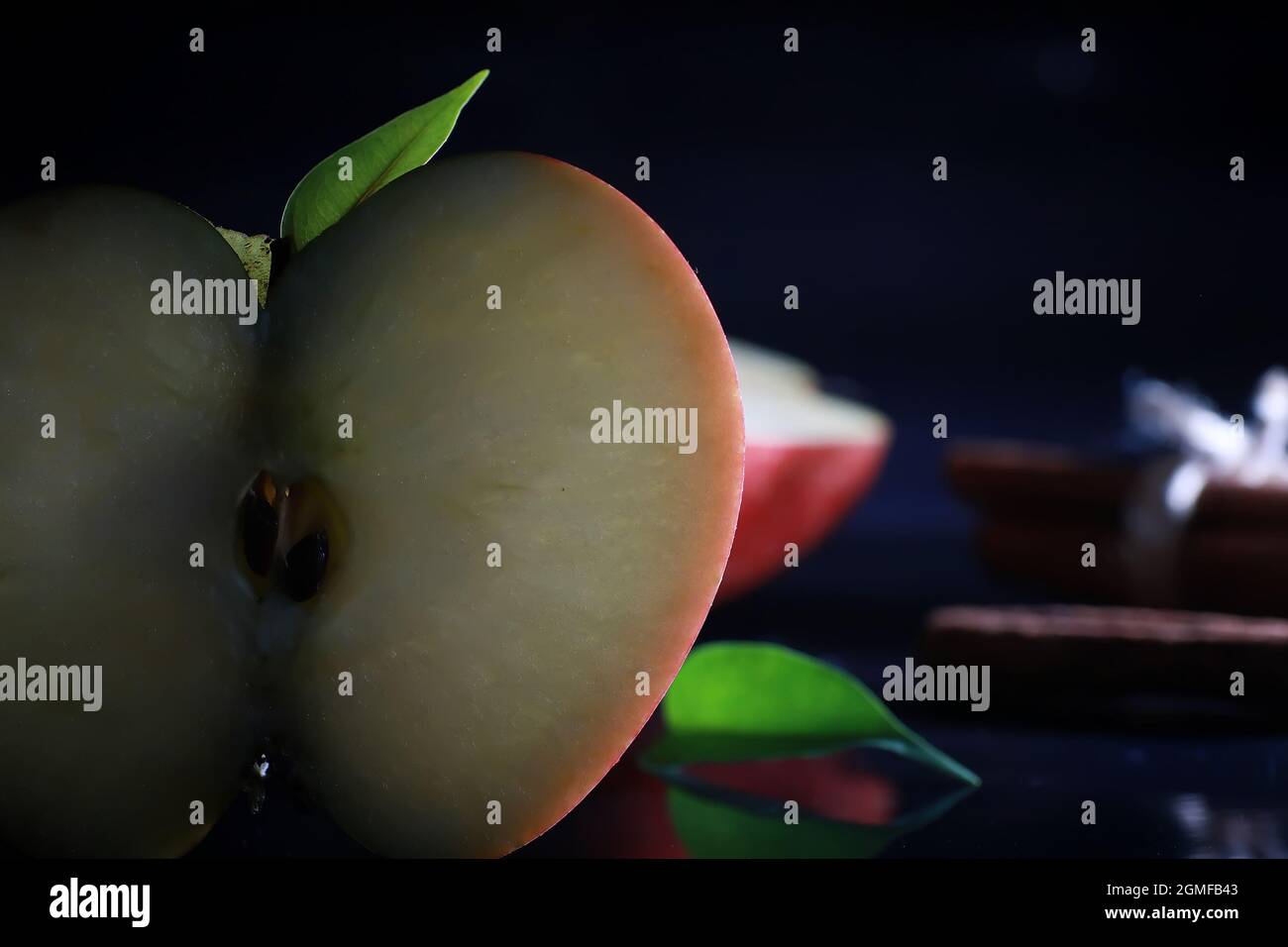 Composition with apple slices on a black background. A slice of apple ...