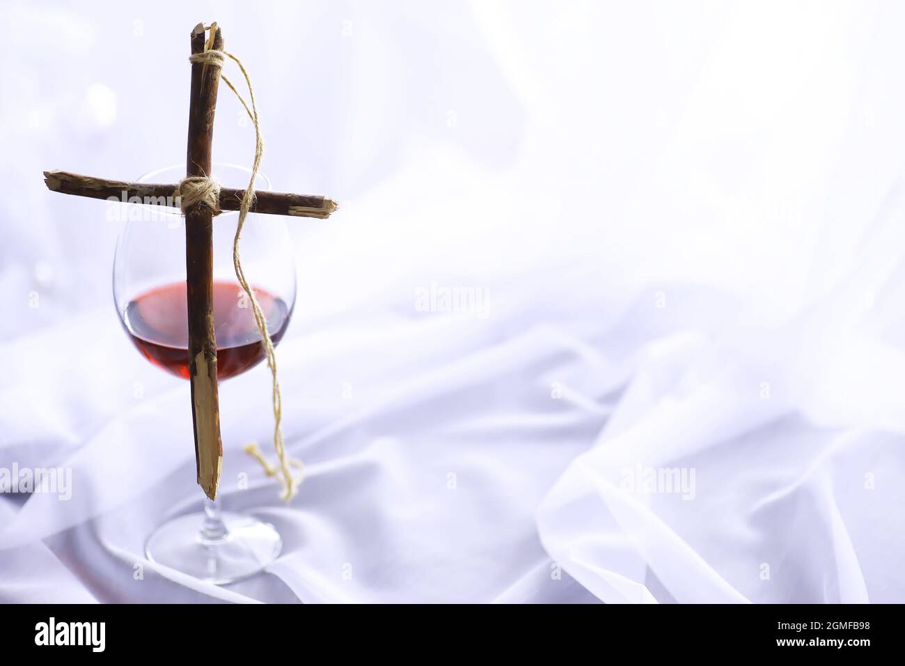 Religious concept. Handmade wooden cross on a white background. Wine ...