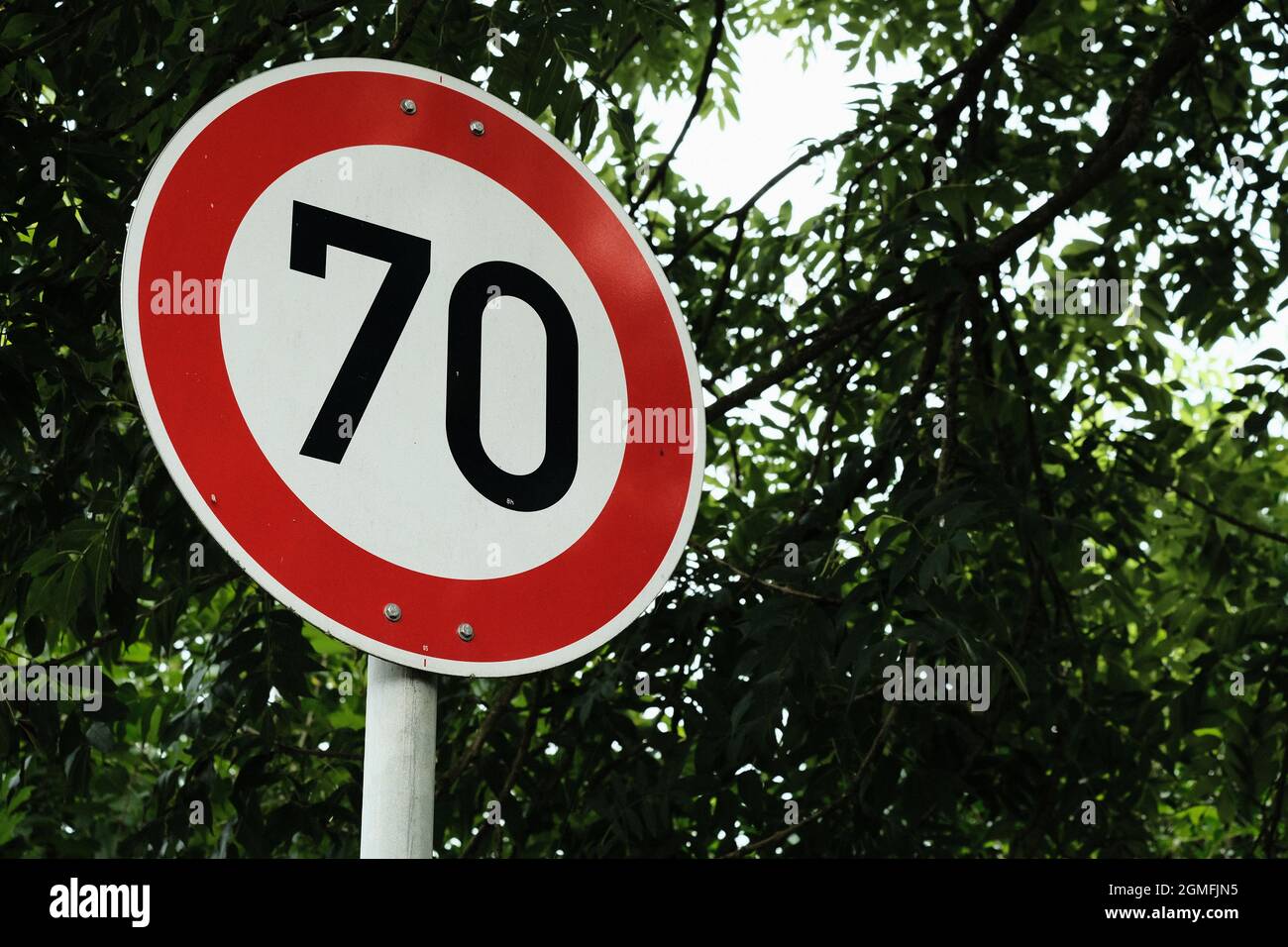 70 mph traffic sign with trees in the background Stock Photo - Alamy