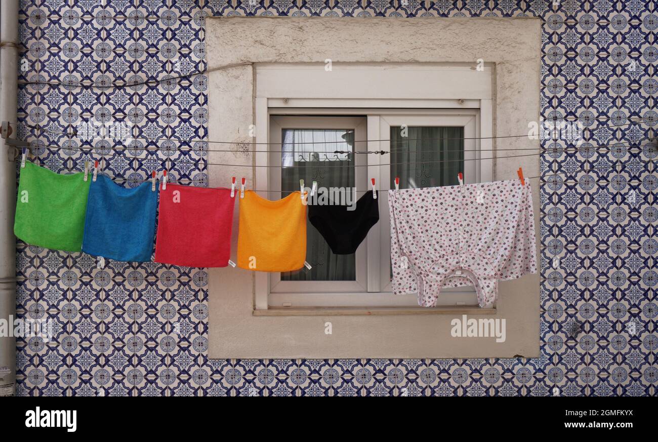 clothes hanging on a clothesline in a window on a wall with painted ...