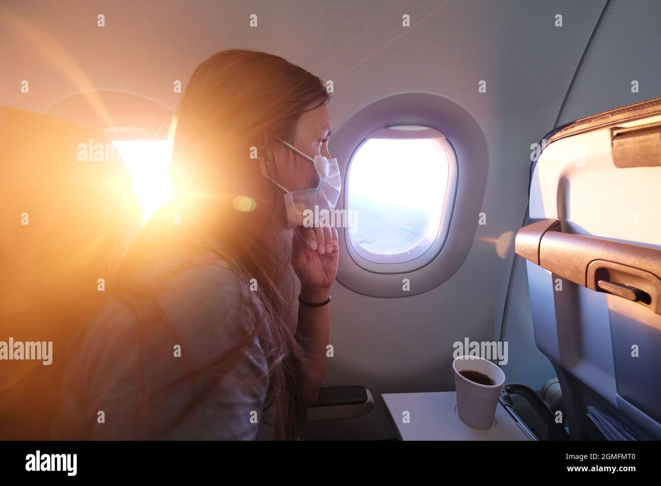 Woman Flying on an Airplane Wearing a Face Mask and Looking in Window ...