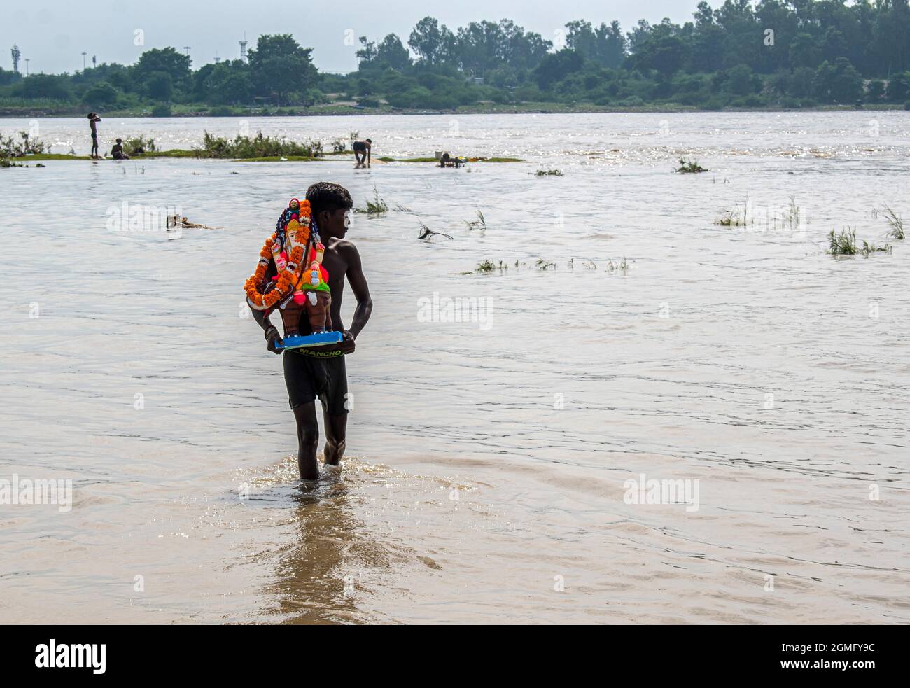 Devotees carry an idol of Ganesha for immersion at the Yamuna Ghat ...