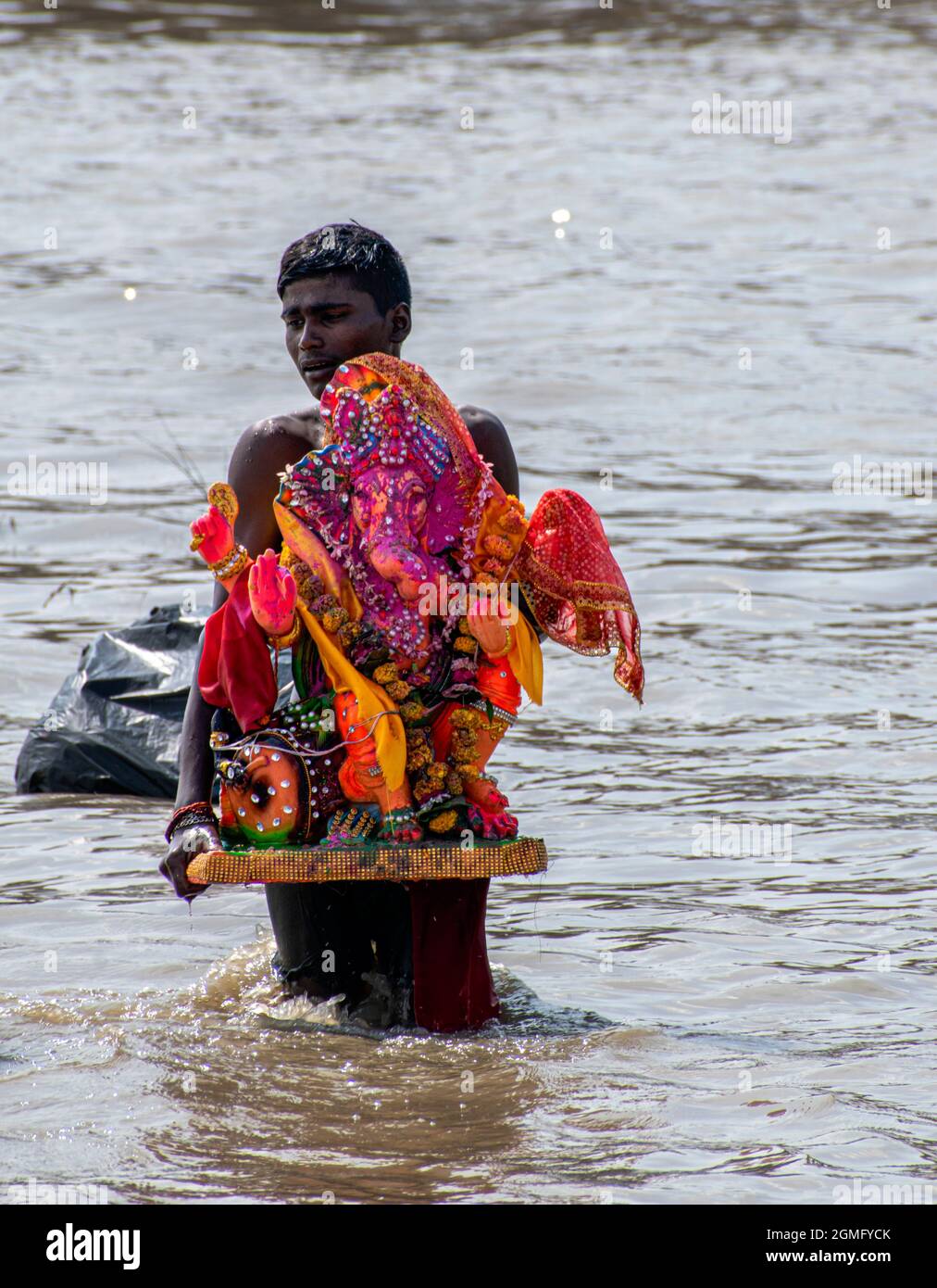 Devotees carry an idol of Ganesha for immersion at the Yamuna Ghat ...