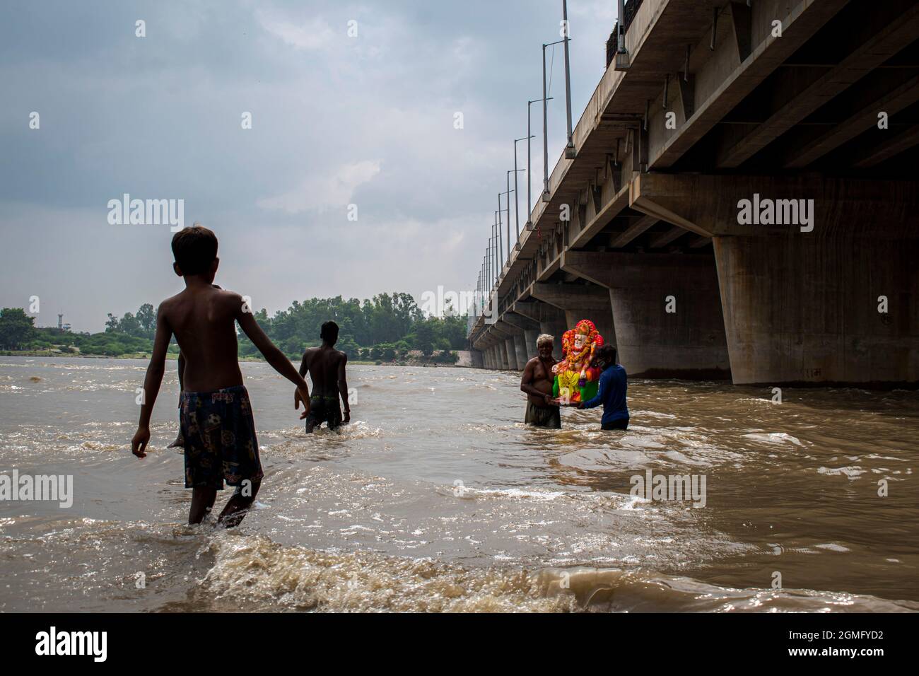 Devotees carry an idol of Ganesha for immersion at the Yamuna Ghat ...