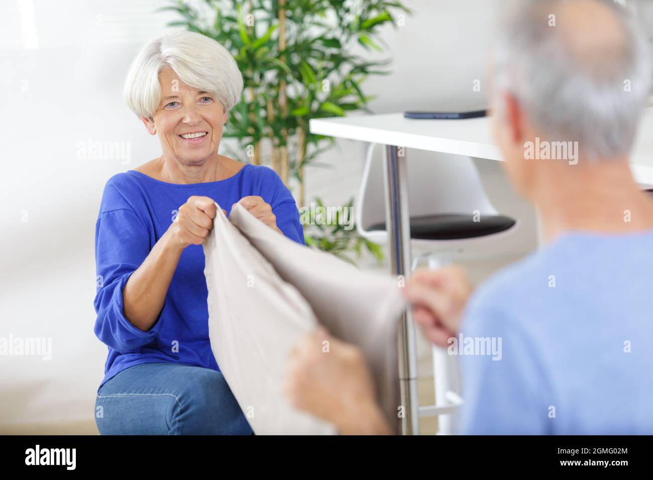couple folding towel in modern laundry room Stock Photo - Alamy