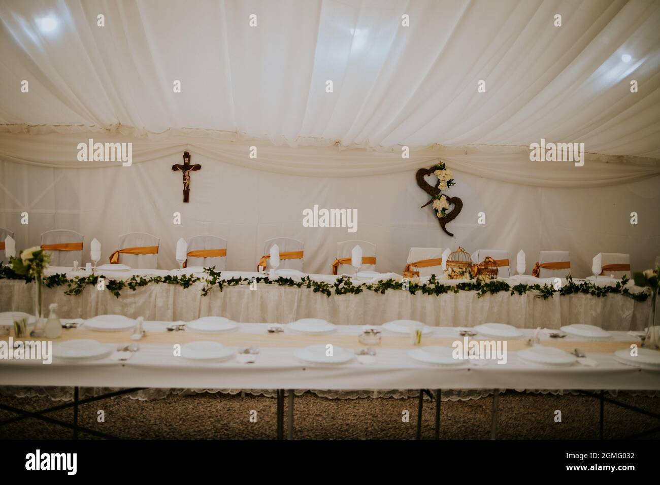 Long tables with white tablecloth and chairs decorated for the wedding ...