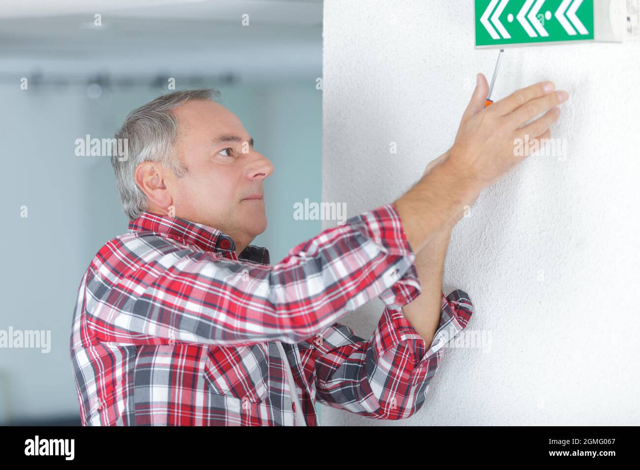 a technician checking emergency sign Stock Photo - Alamy