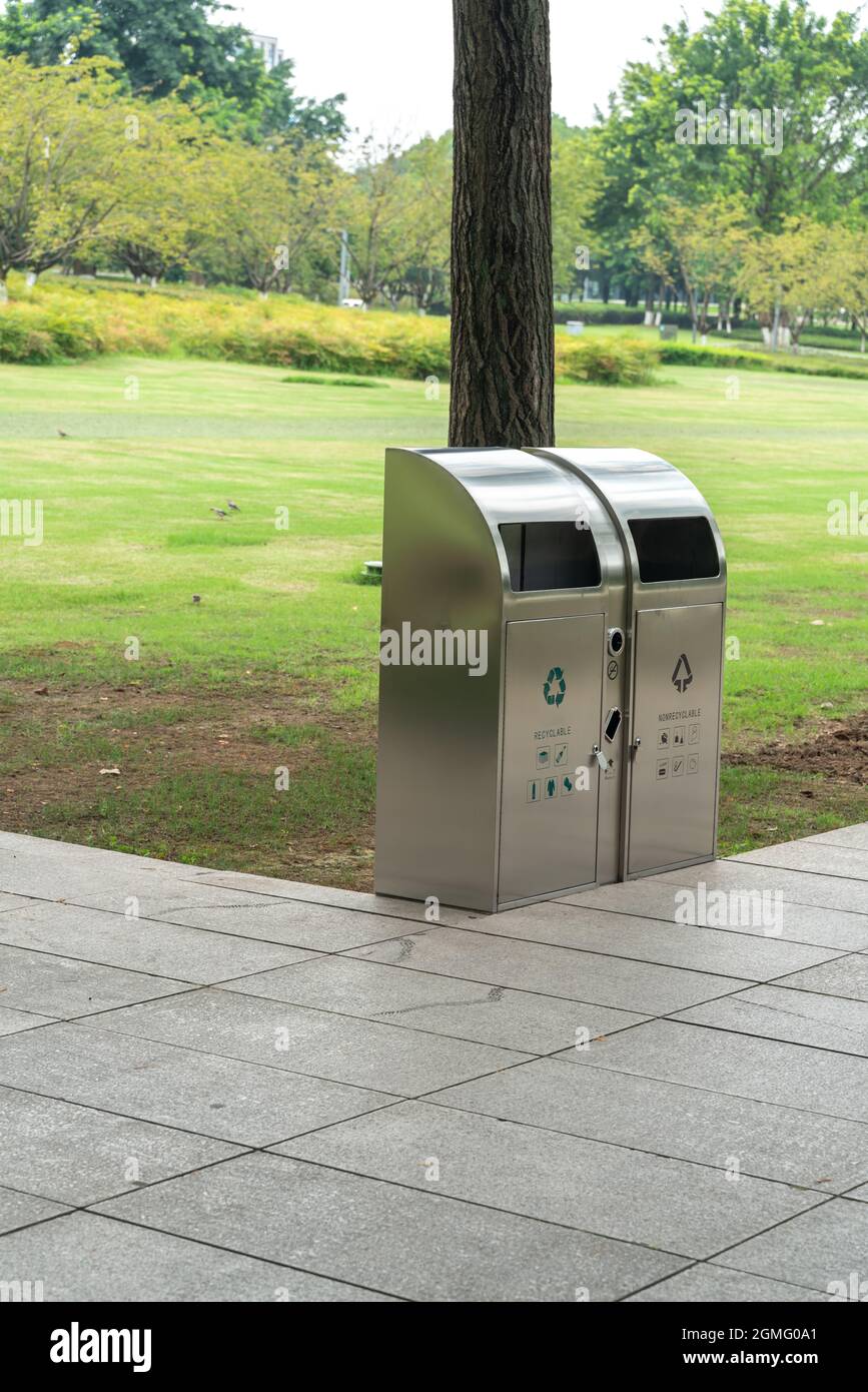 Vertical shot of trash cans in a modern park with a green and clean ...