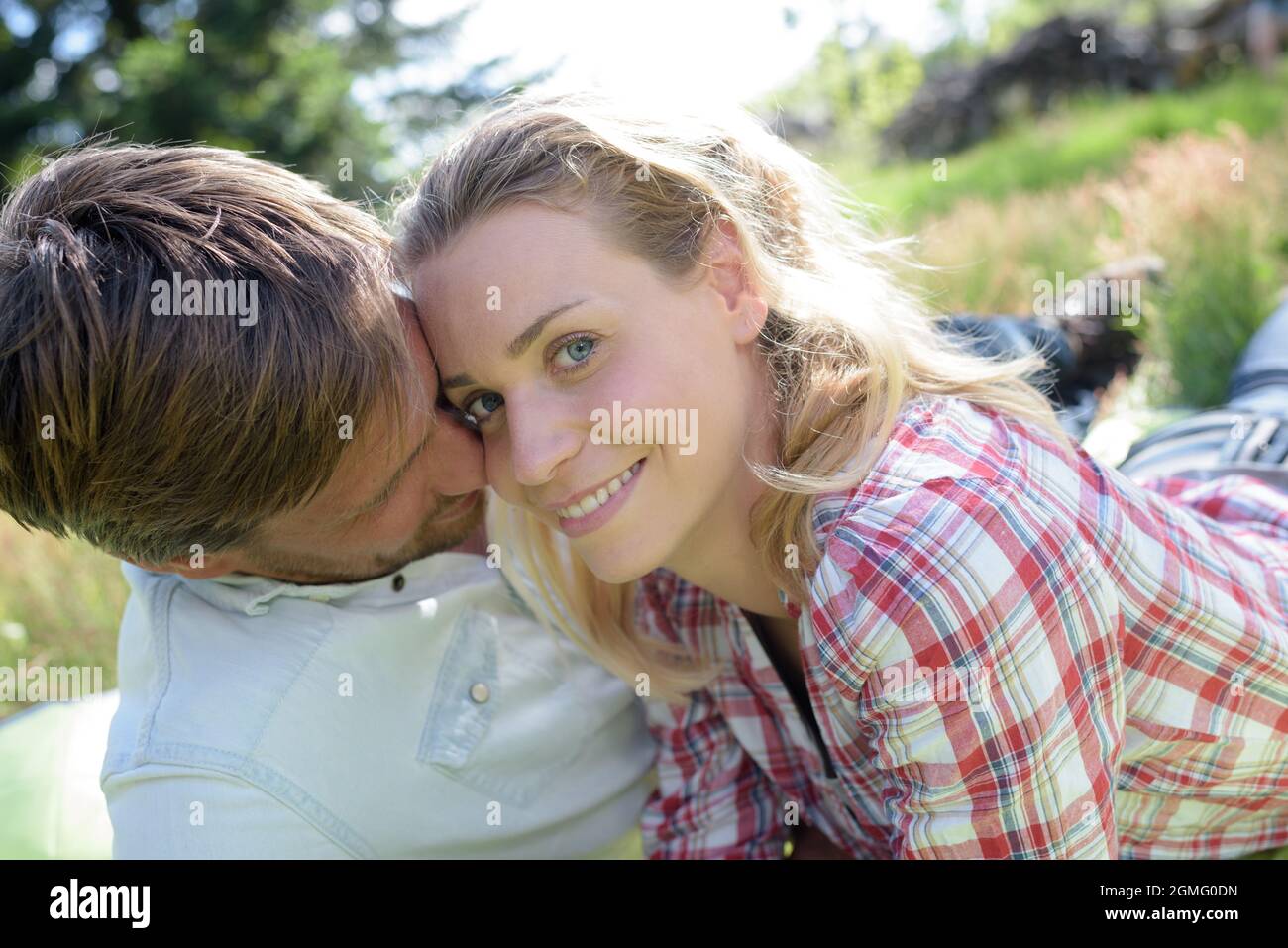 couple laying in the grass and kissing Stock Photo - Alamy