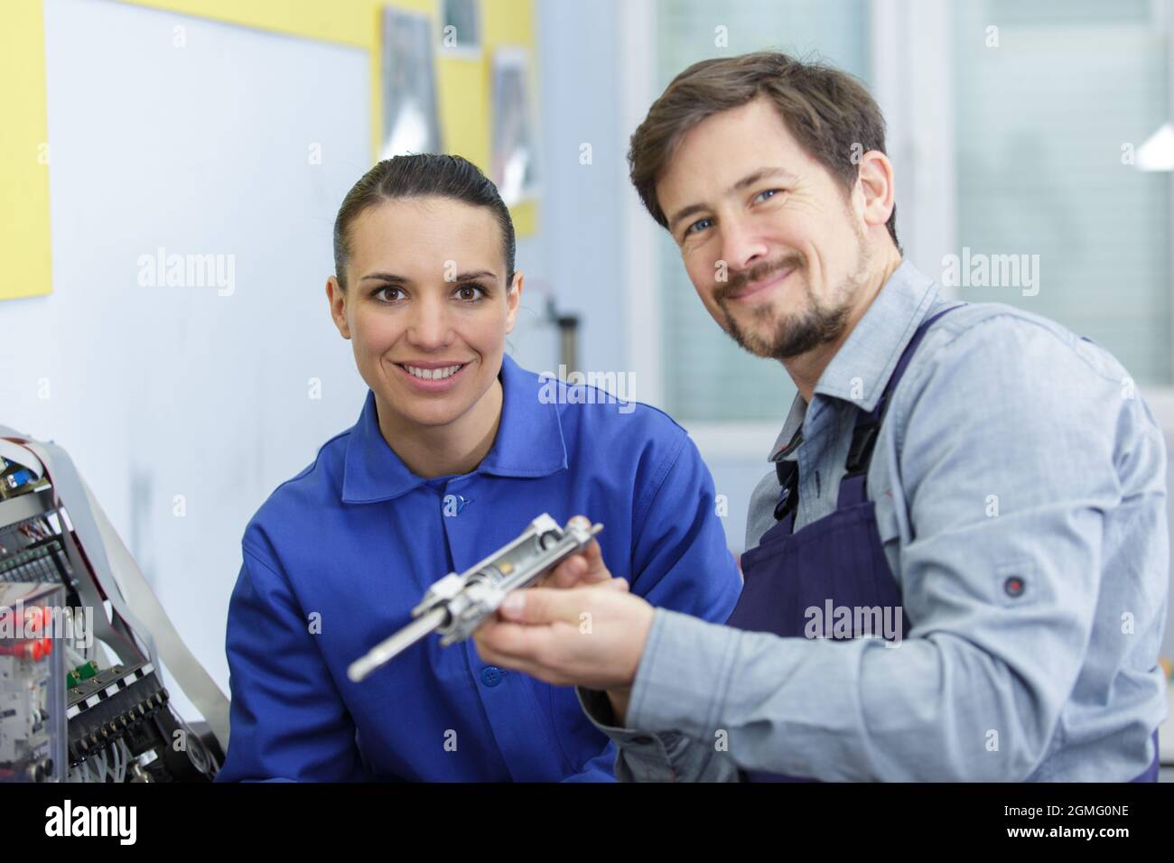 engineer working with apprentice holding machinery part Stock Photo - Alamy