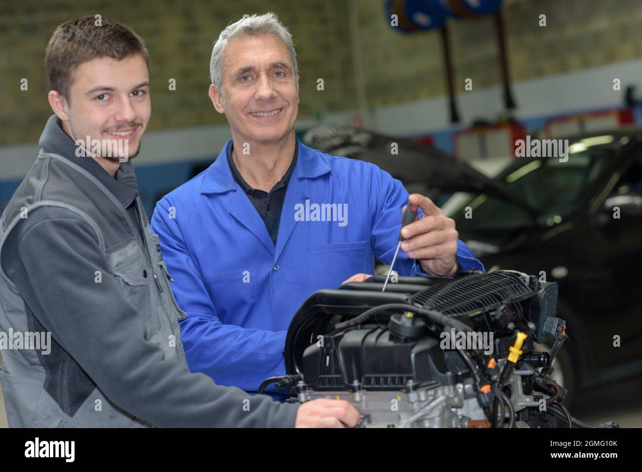 student with instructor repairing a car during apprenticeship Stock ...