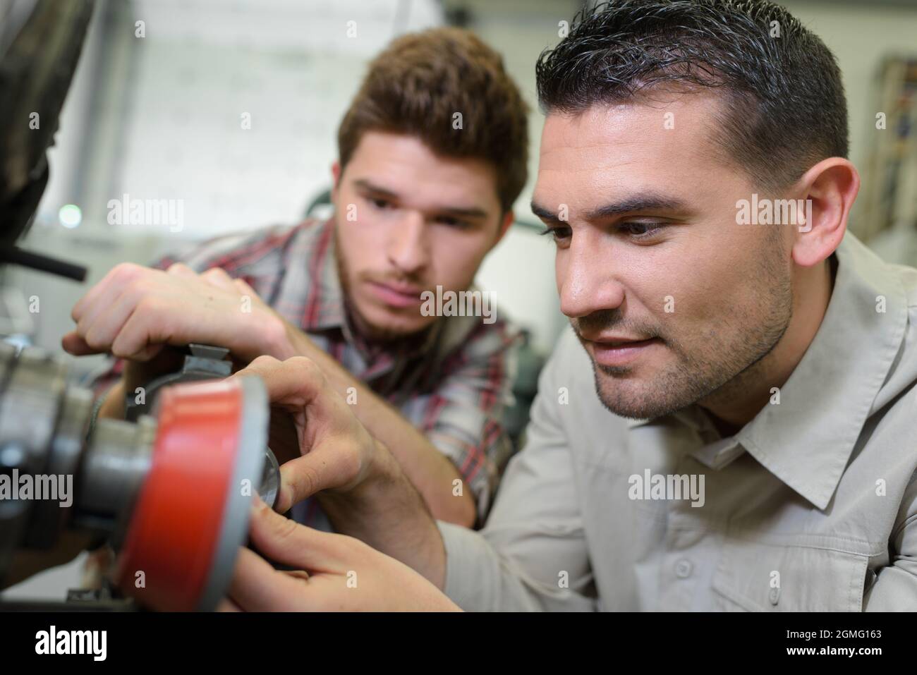 man showing working of machinery to apprentice Stock Photo - Alamy