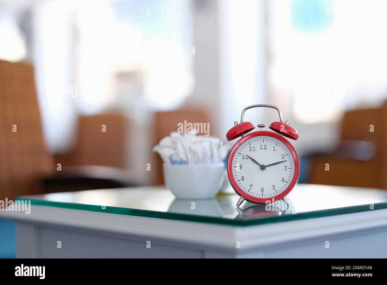 Red classic alarm clock standing on table in cafe closeup Stock Photo ...