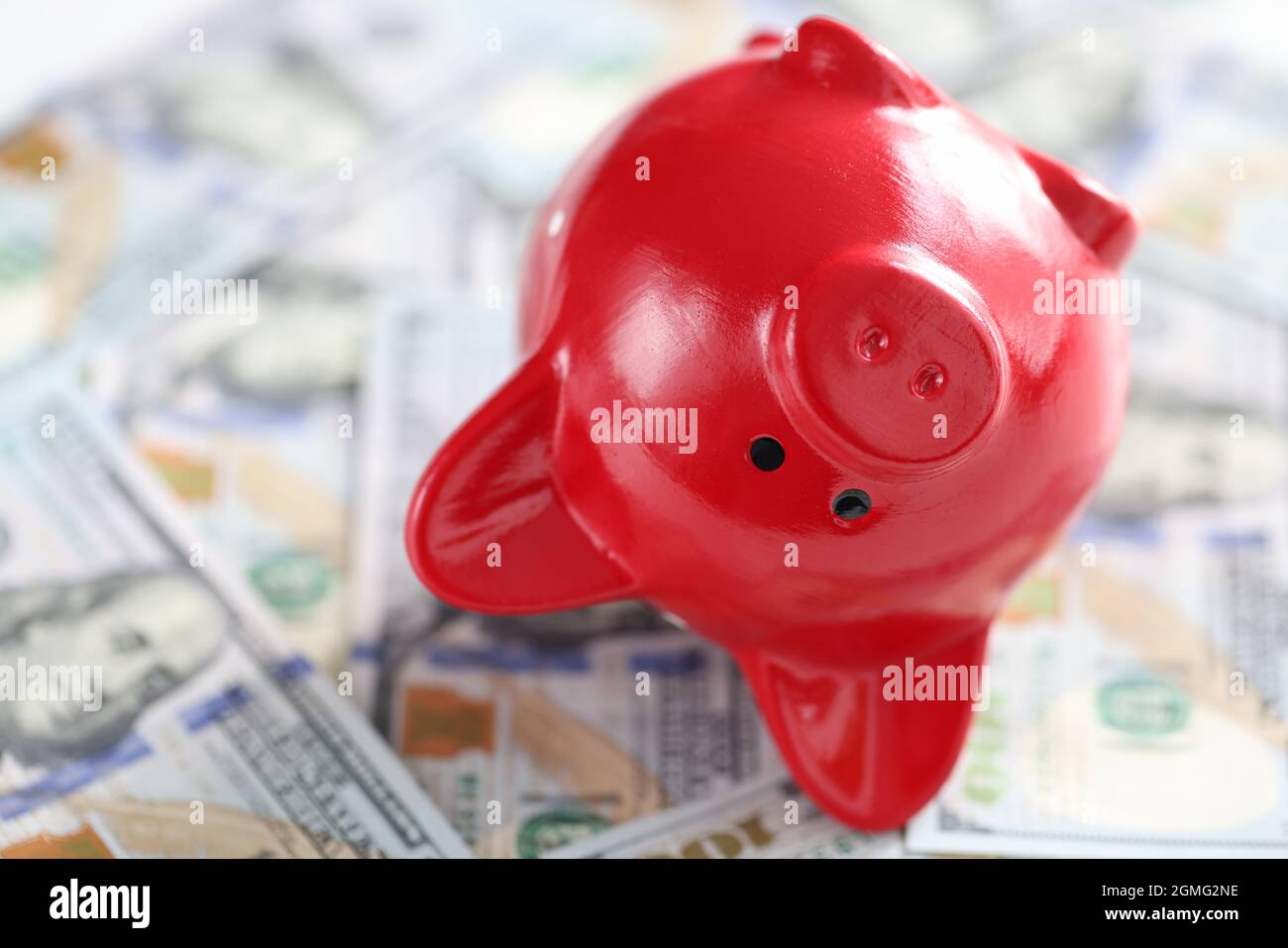 Inverted red piggy bank lies on one hundred dollar bills Stock Photo ...