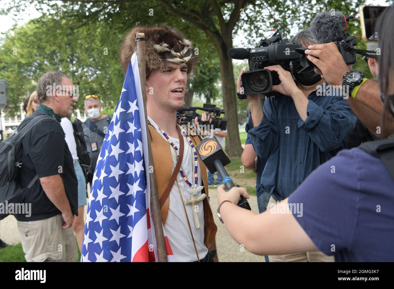 A sympathizer wears religion symbol as a chaman speaks during a rally ...