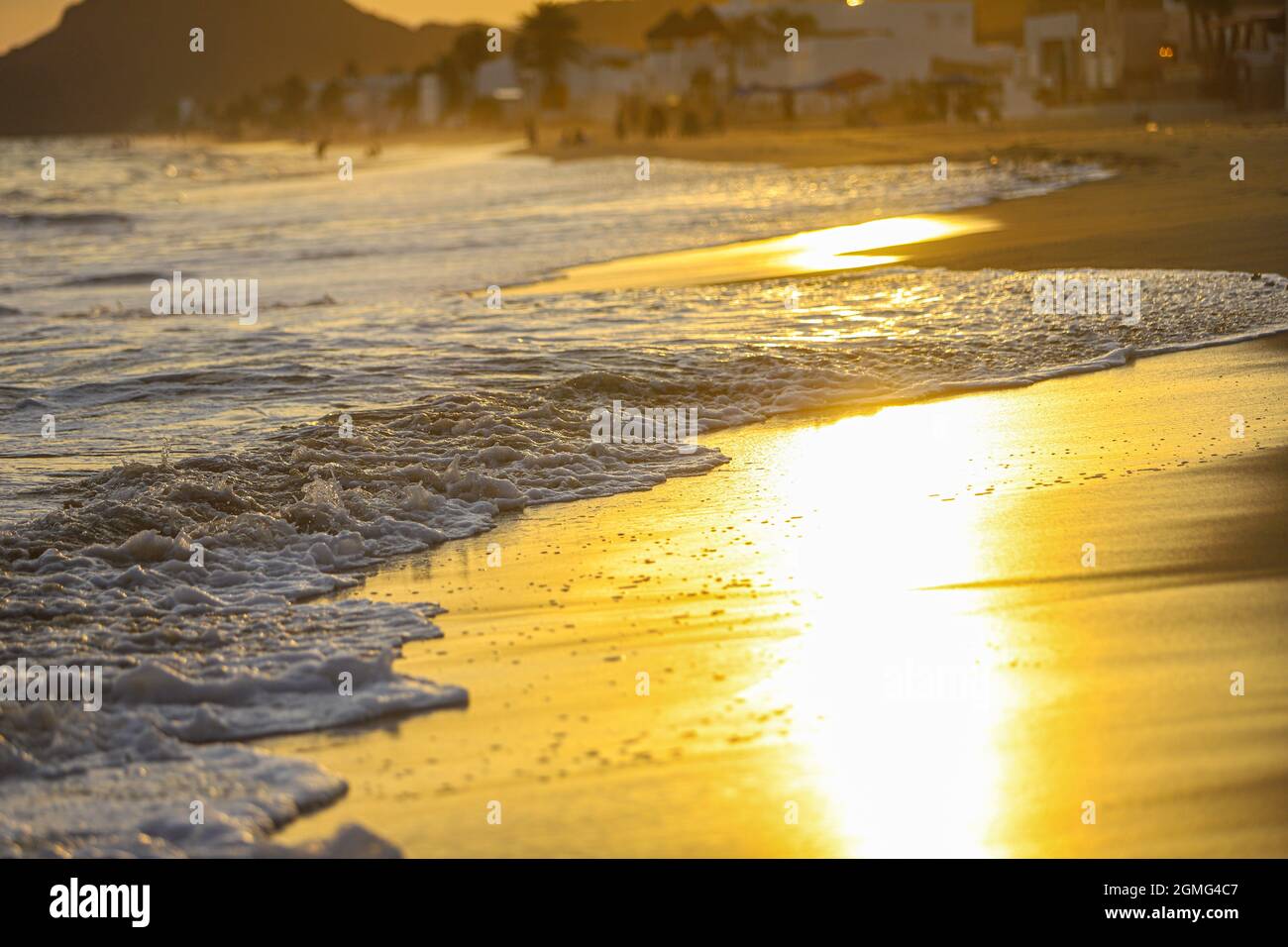 Sand and ocean water waves on the Bahia de Kino beach at sunset in ...