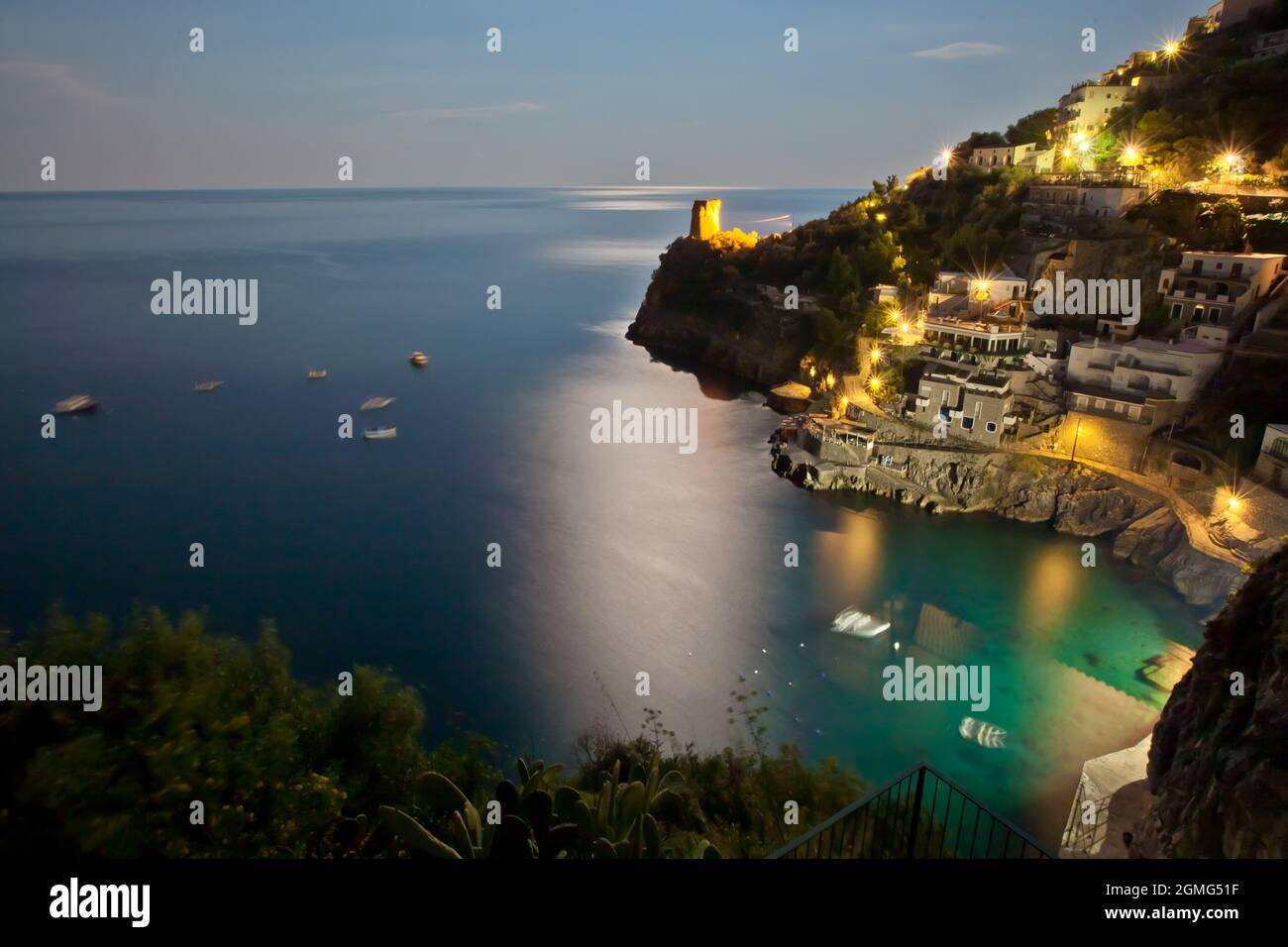 View of the illuminated harbor of Praiano, Italy at night on the Amalfi ...