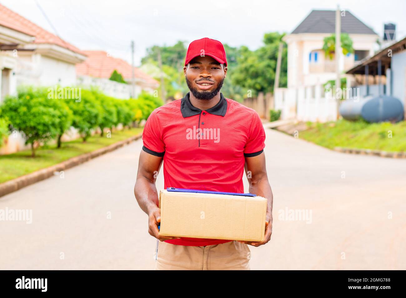 african delivery worker holding a package Stock Photo - Alamy