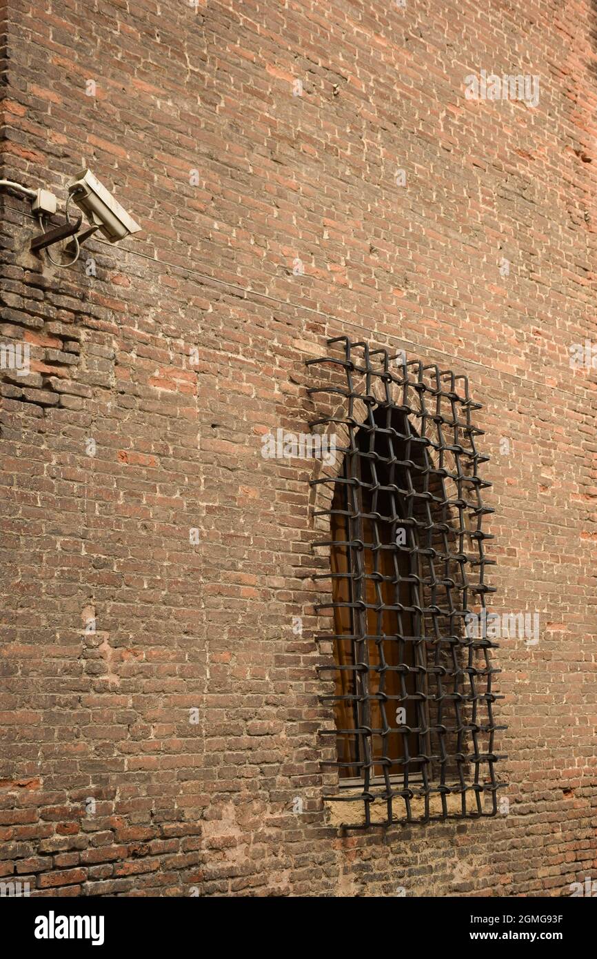 On an old brick wall hangs a wrought iron grate on the window. A video ...