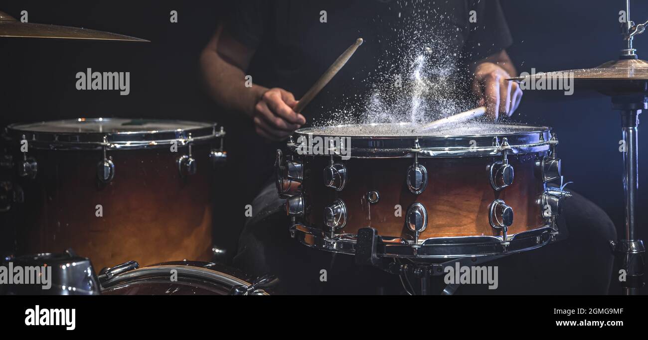 A male drummer plays snare drum with drumsticks in a dark room Stock ...